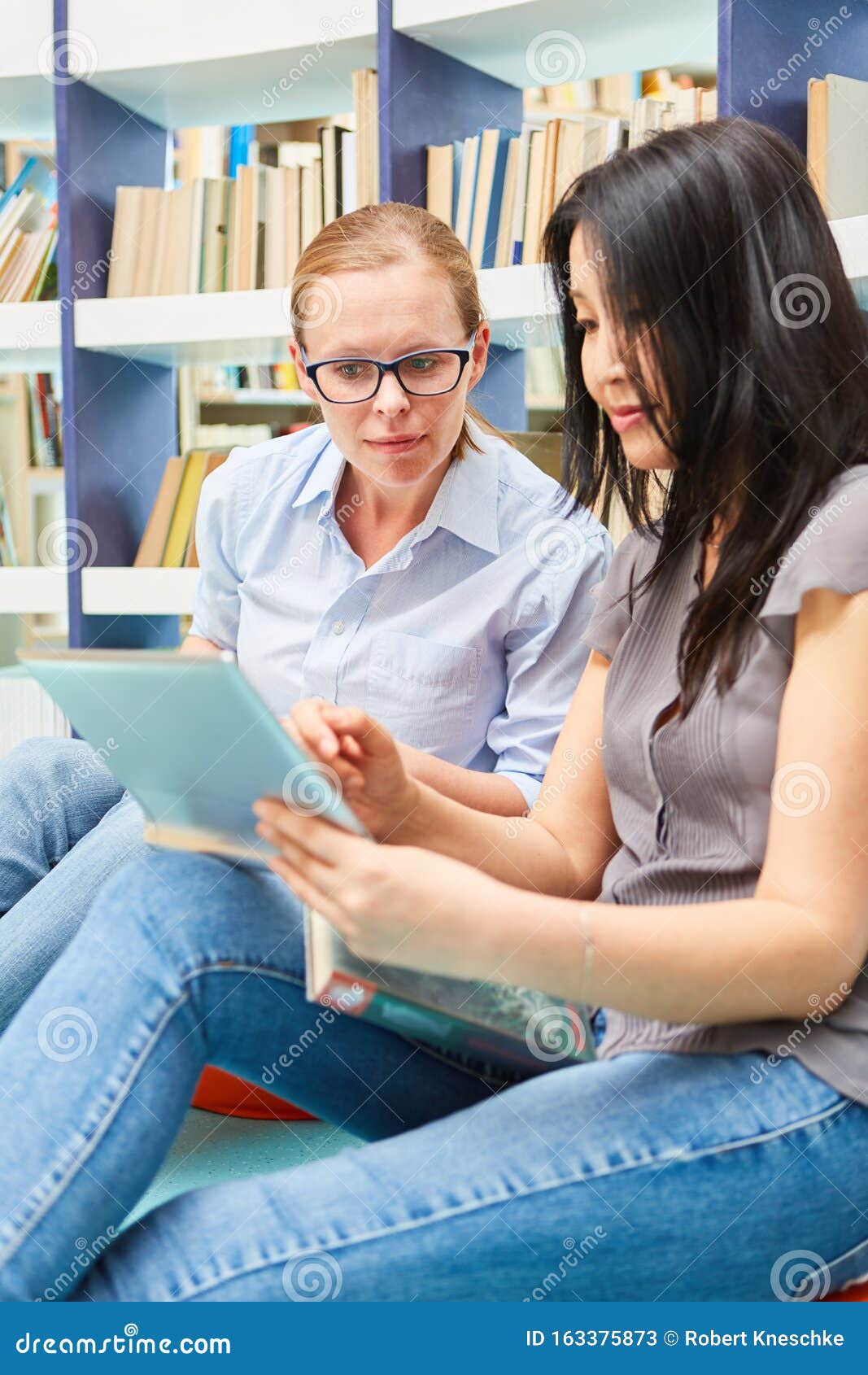 Two Young Women with Book and Tablet Computer Stock Image - Image of ...