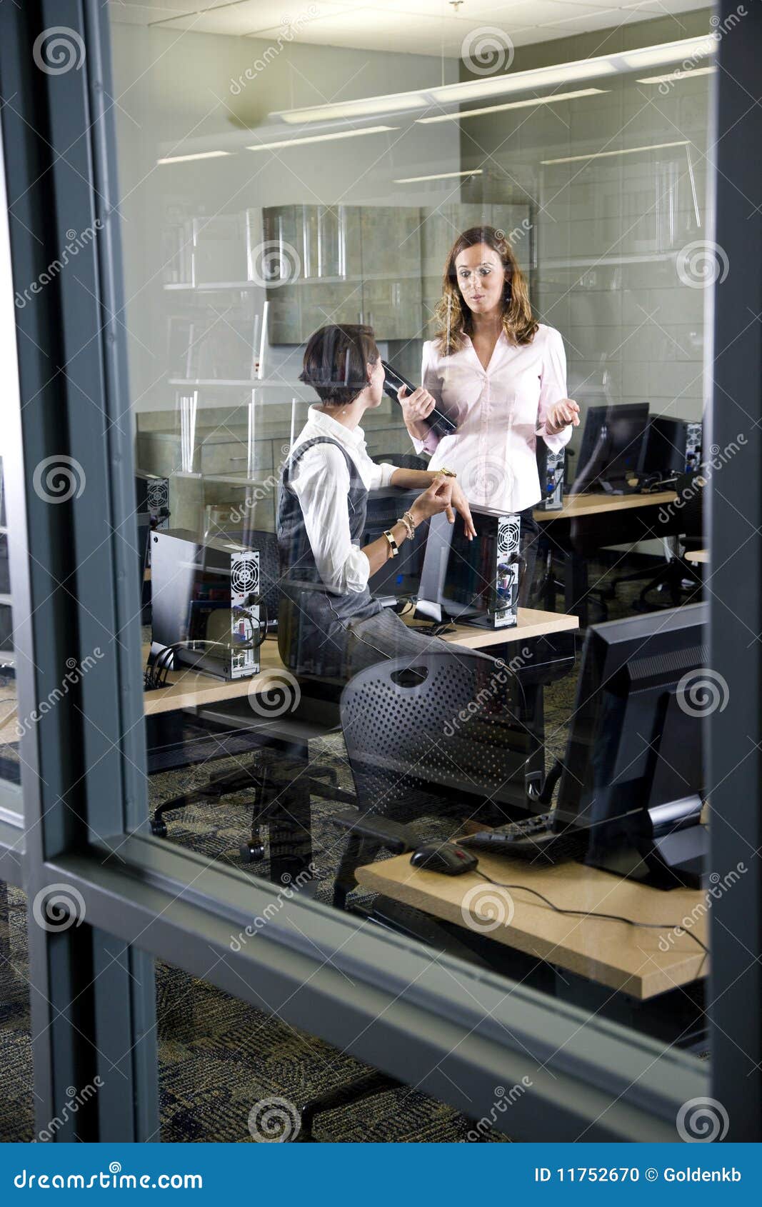 Two Young Women Conversing in Computer Lab Stock Photo - Image of ...