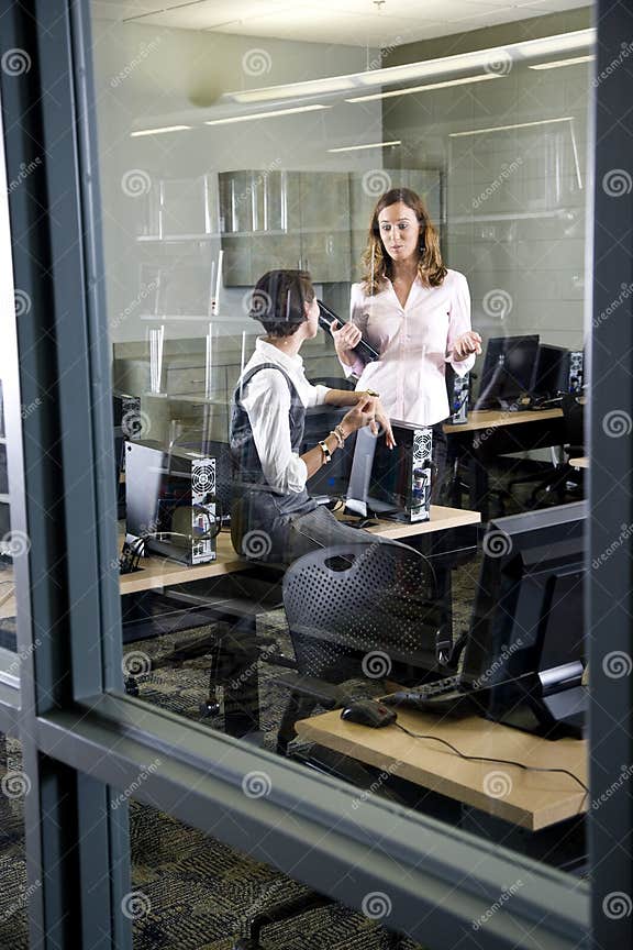 Two Young Women Conversing in Computer Lab Stock Photo - Image of ...