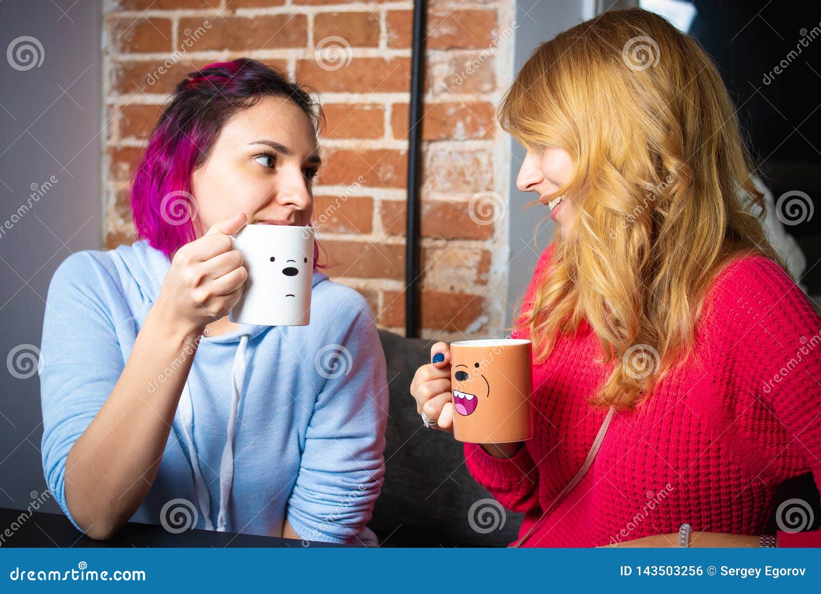 Two Young Women with the Cups of Tea and Coffee Talking Stock Photo ...