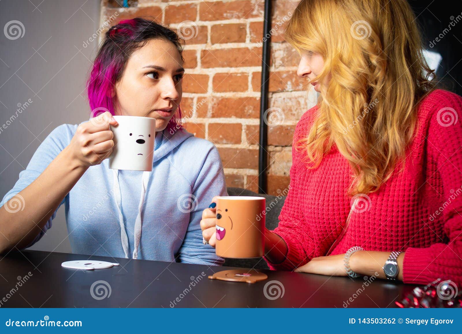 Two Young Women with the Cups of Tea and Coffee Talking Stock Photo ...