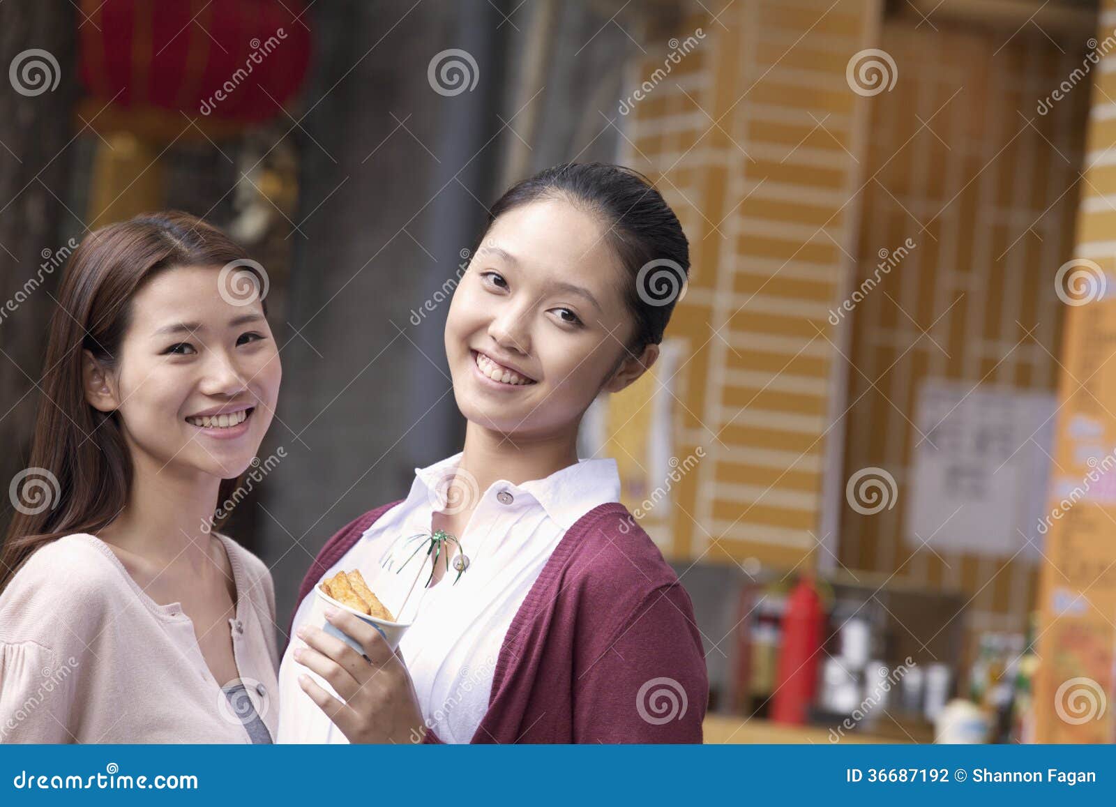 Two Young Women Eating Snacks Stock Photo - Image of head, culture ...