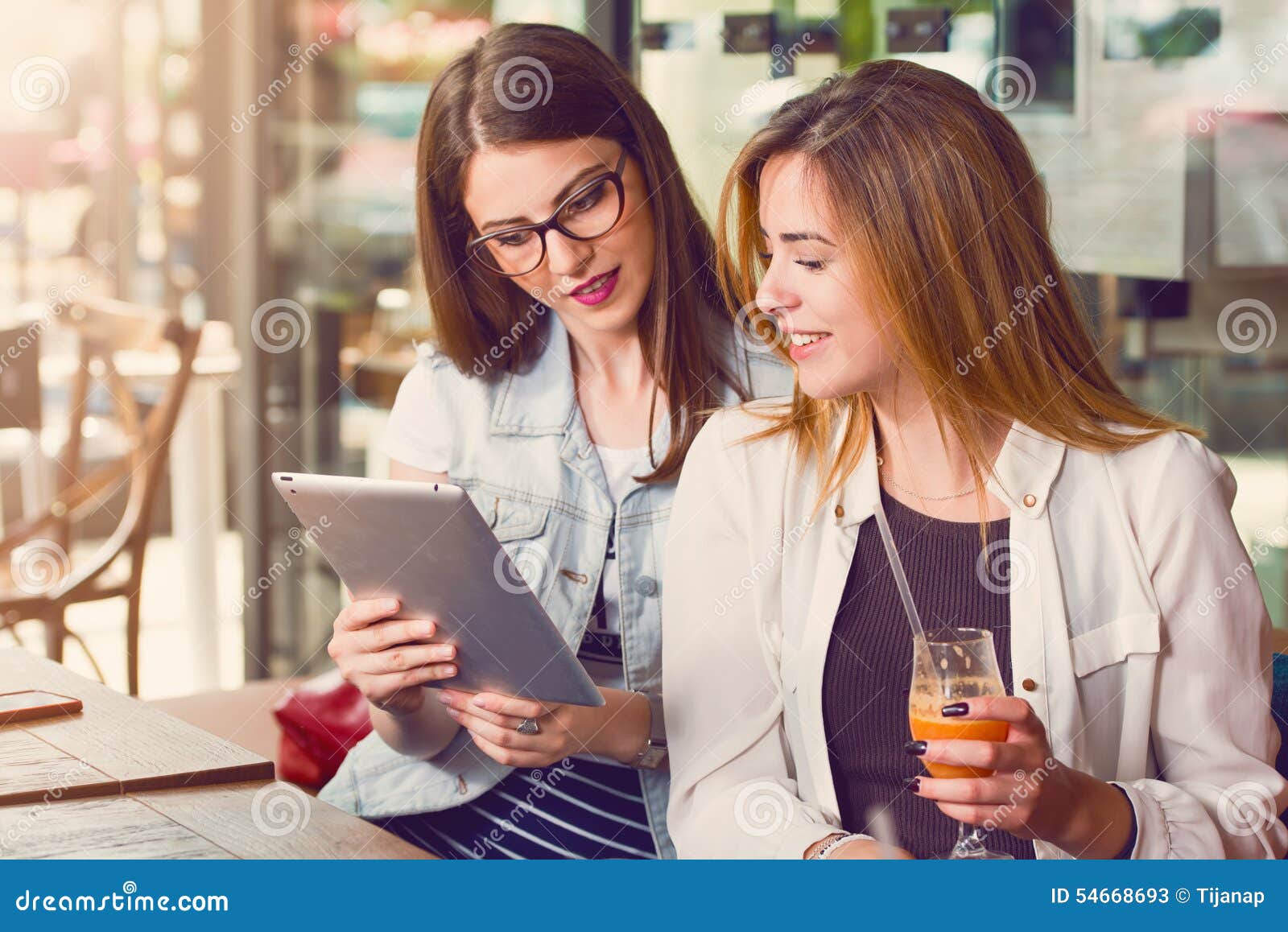 Two Young Women Looking at a Tablet Stock Image - Image of people ...