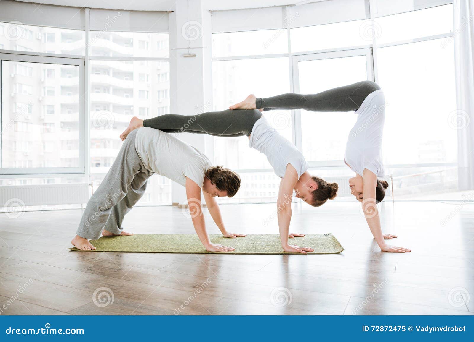 Two Young Women and Man Practicing Acro Yoga Stock Image - Image of ...