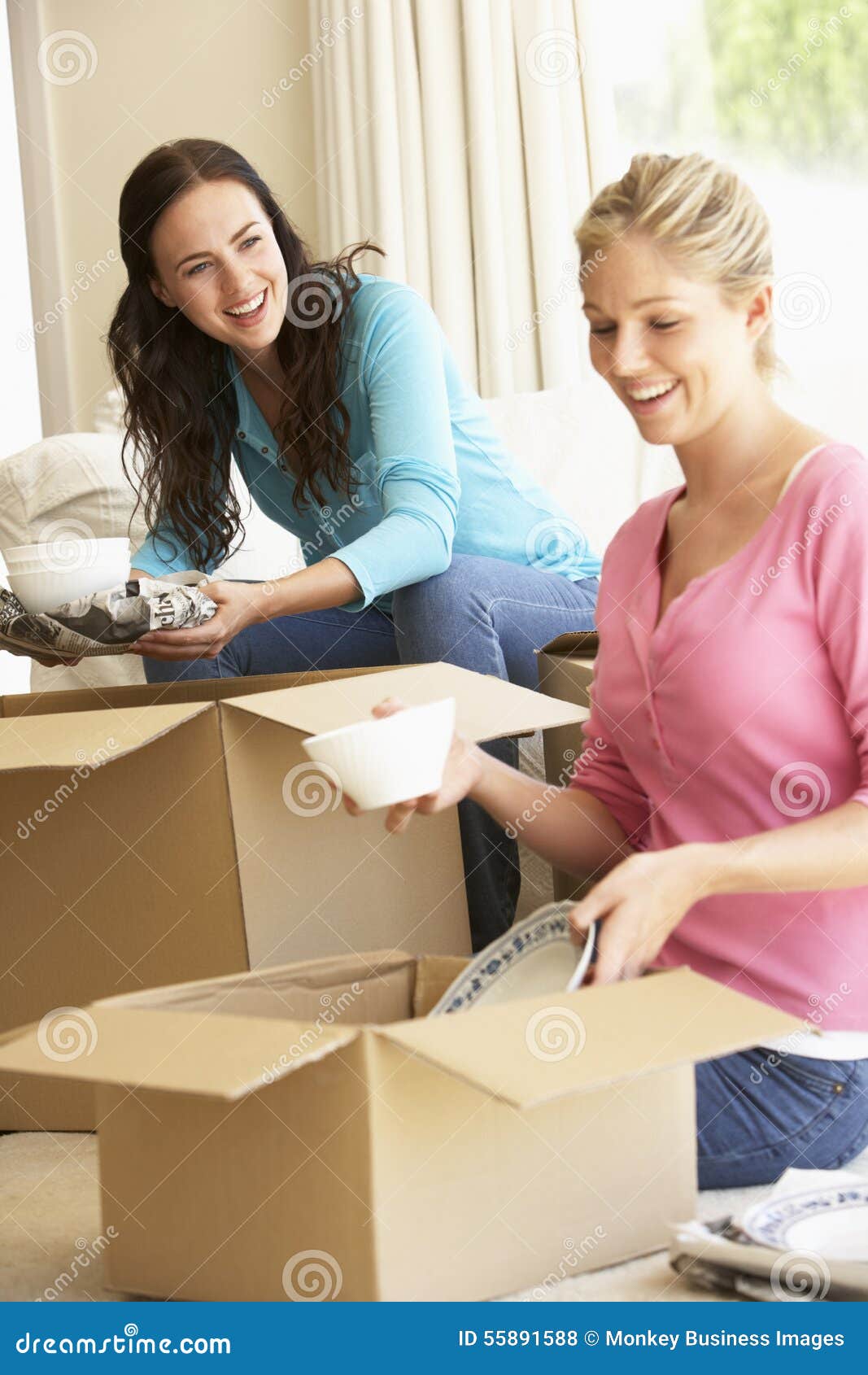 Two Young Women Moving into New Home Unpacking Boxes Stock Photo ...