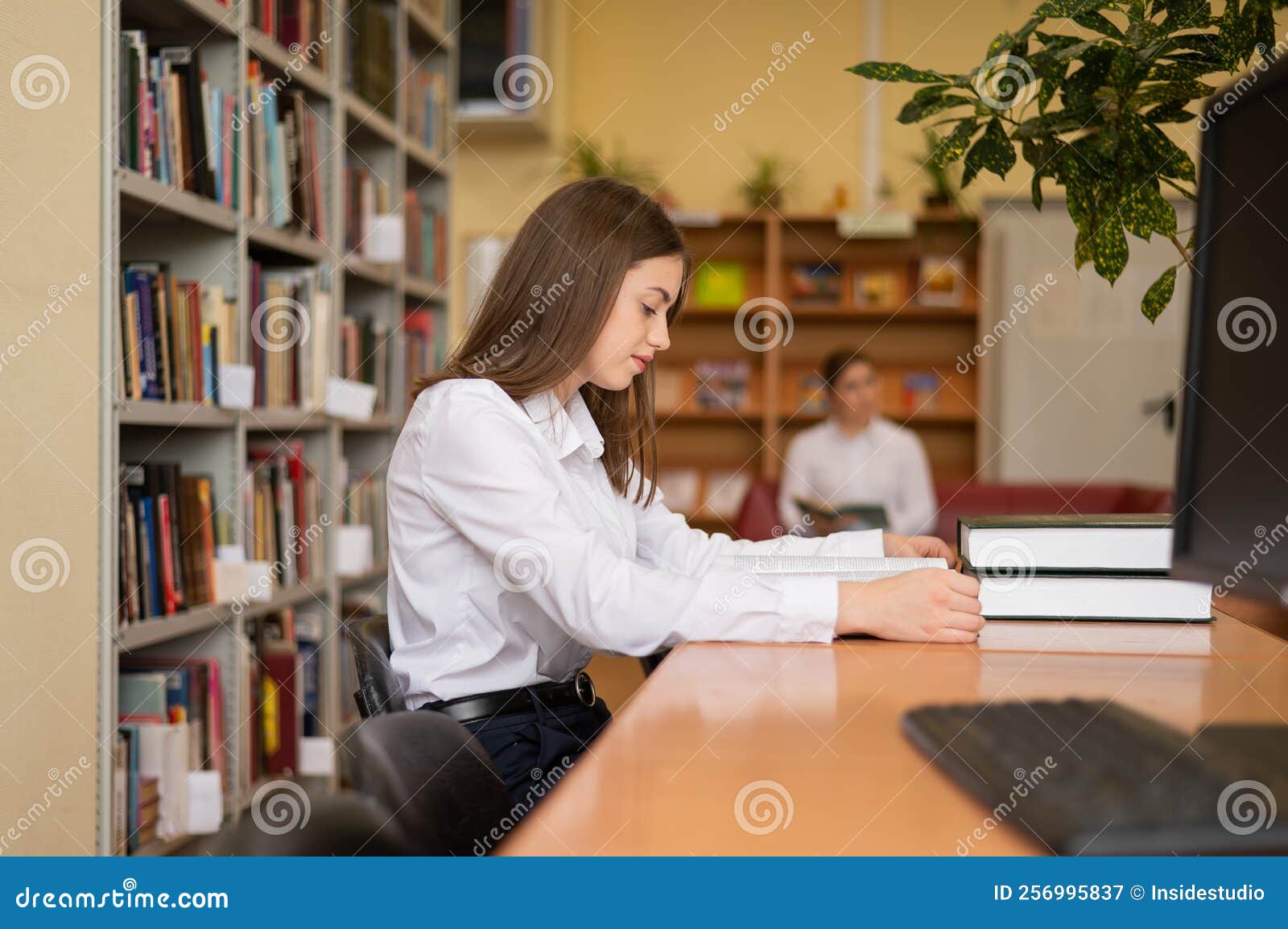 Two Young Women Reading Books in a Public Library. Stock Image - Image ...