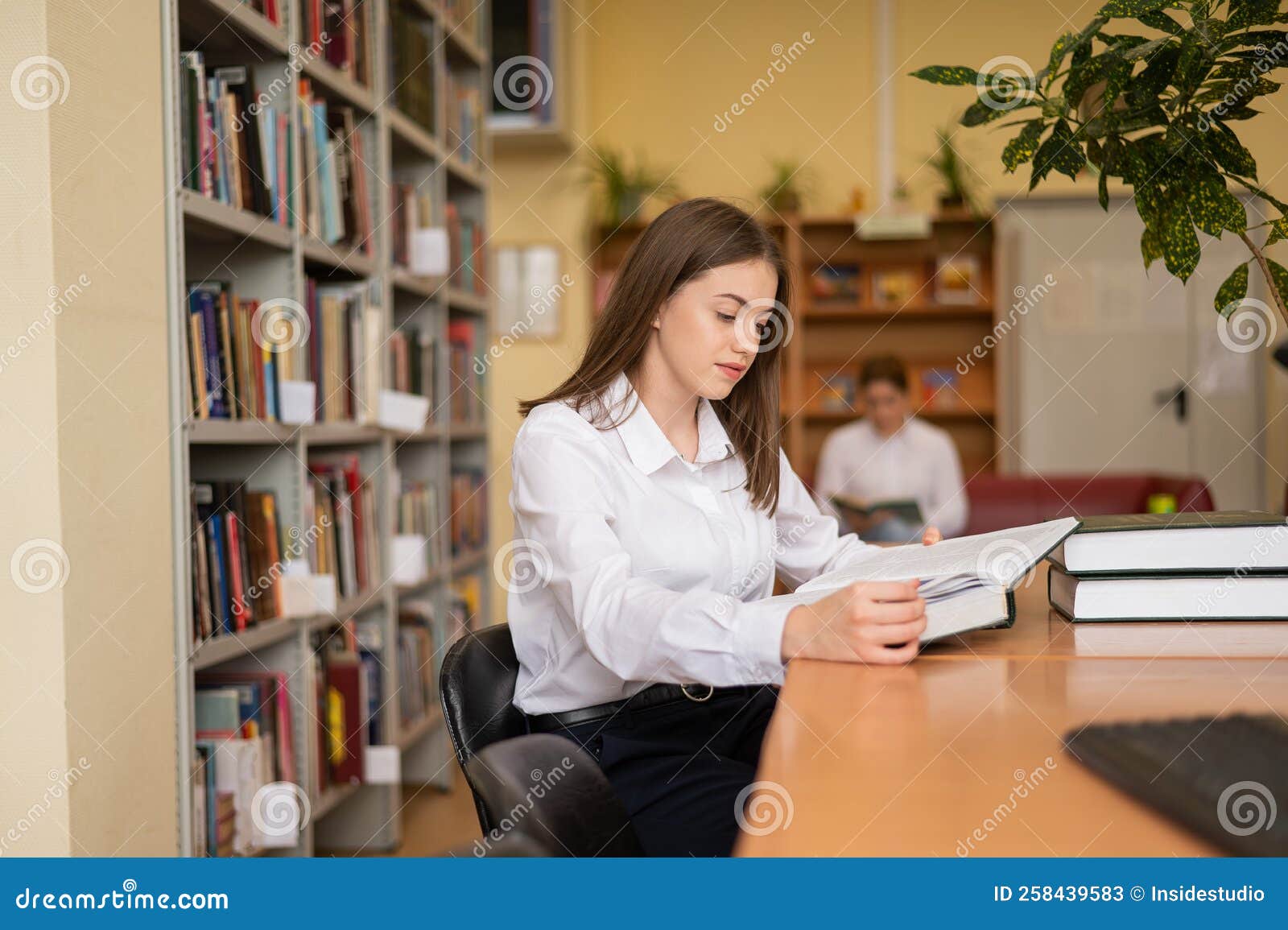 Two Young Women Reading Books in a Public Library. Stock Image - Image ...