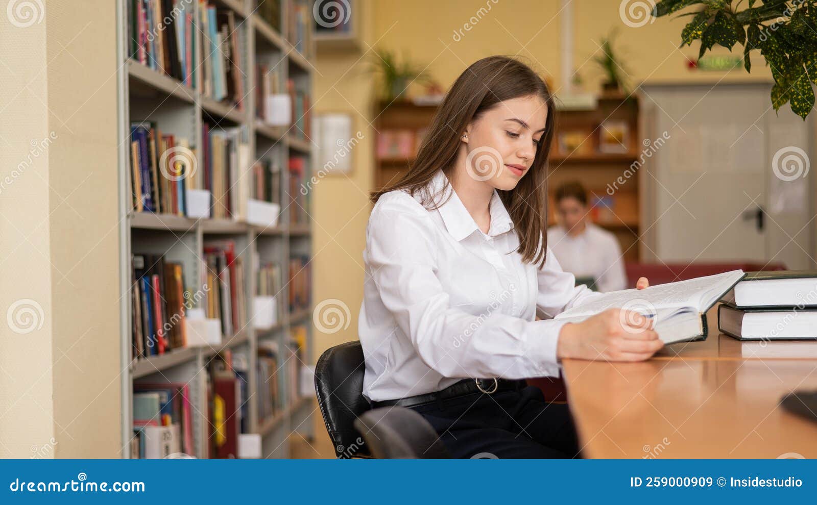 Two Young Women Reading Books in a Public Library. Stock Image - Image ...