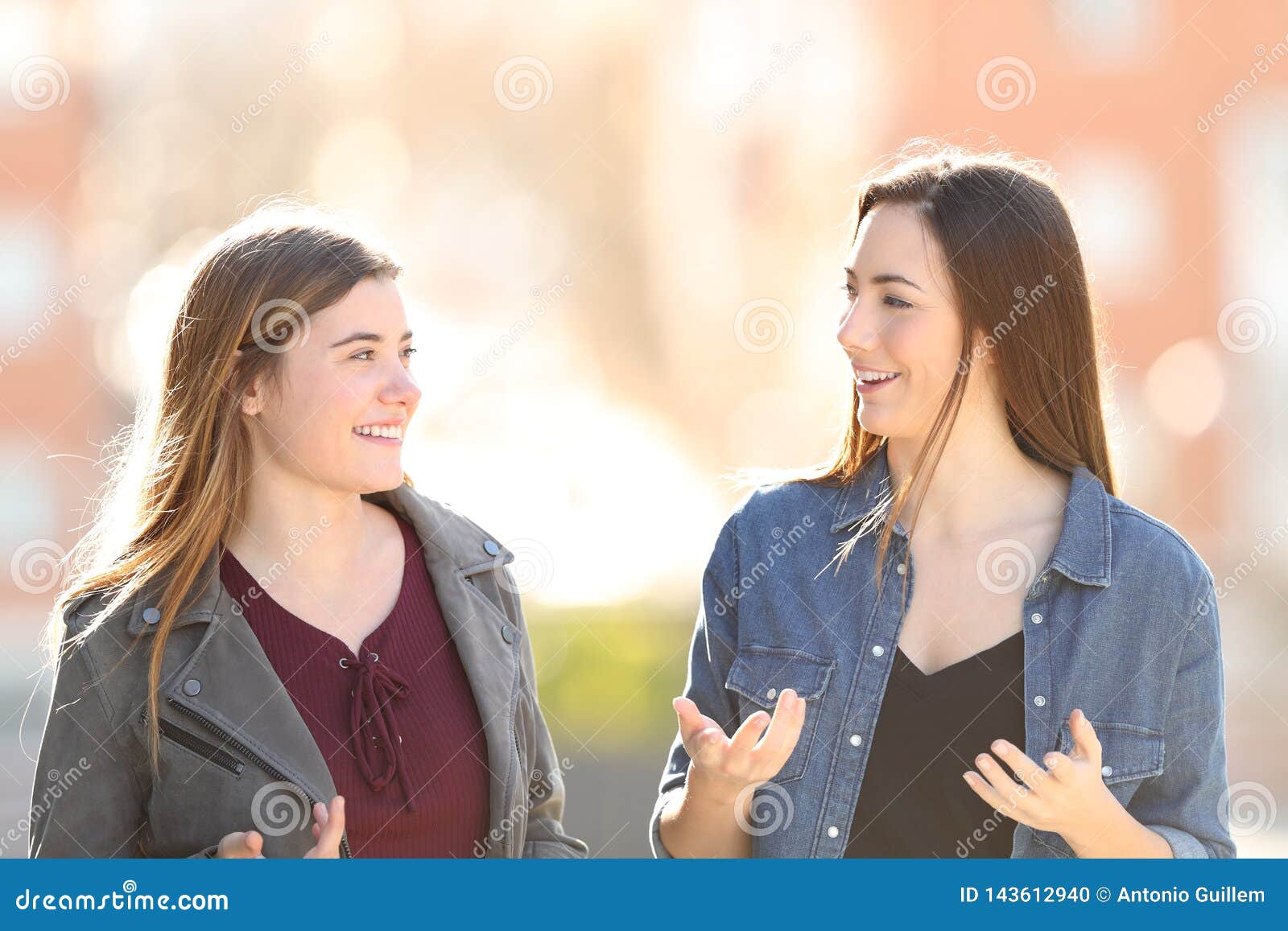 Two Young Women Walking and Talking in the Street Stock Photo - Image ...