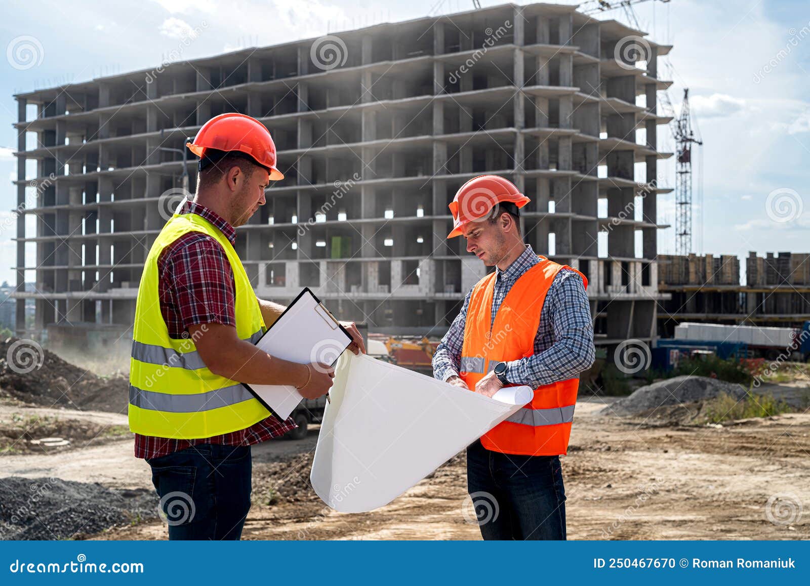 Two Young Workers in Uniforms Discuss the Process of Building a House ...