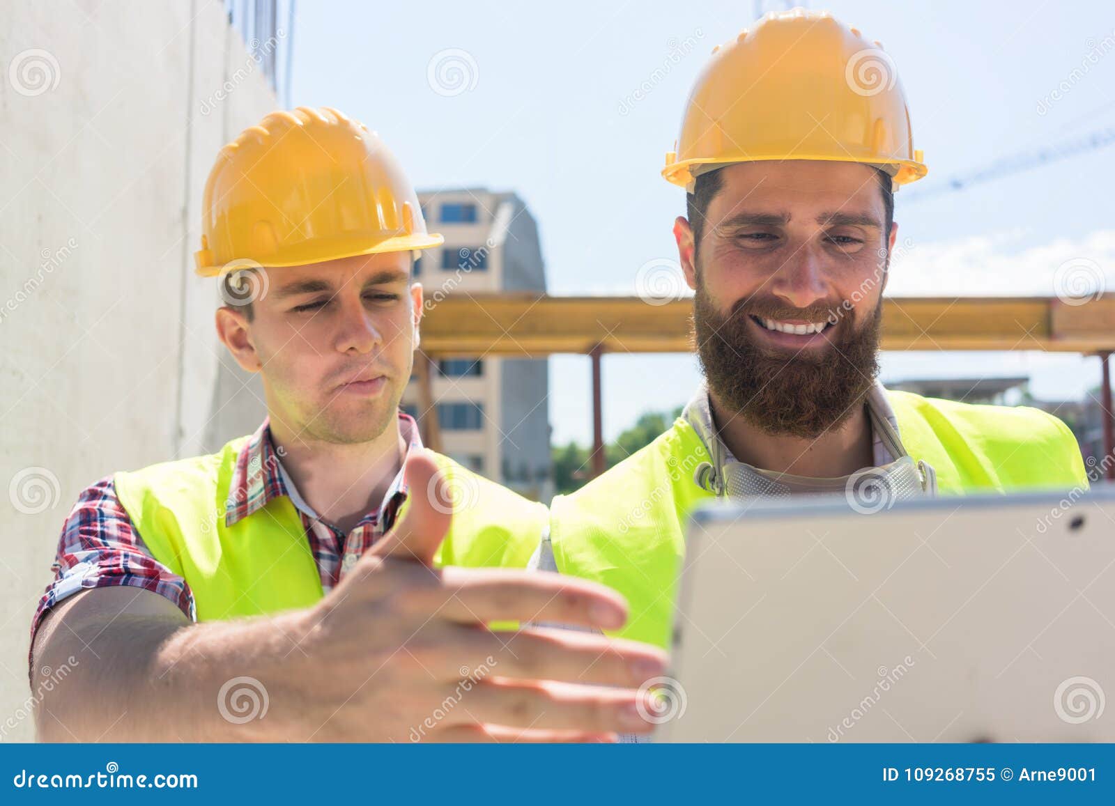 Two Young Workers Watching a Video or Communicating Online through ...