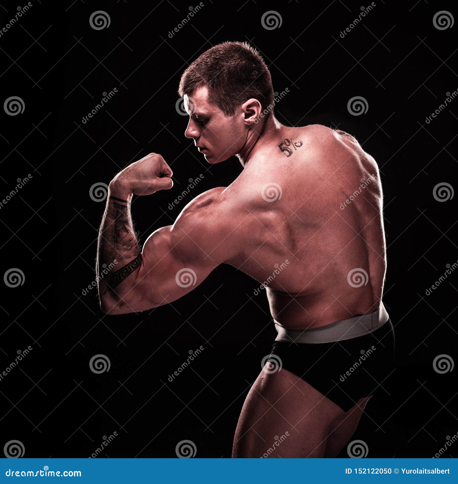 Type Beau De Bodybuilder Montrant Le Biceps Sur Son Bras Photo Stock