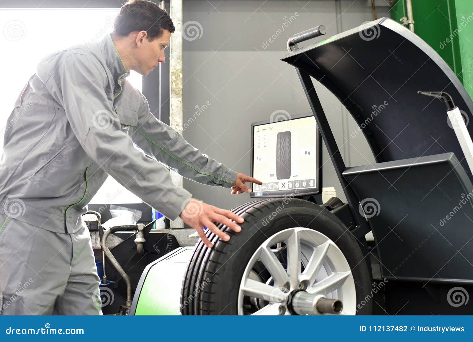Tyre Change in a Garage - Assembler Balancing a Tyre on the Mach Stock ...