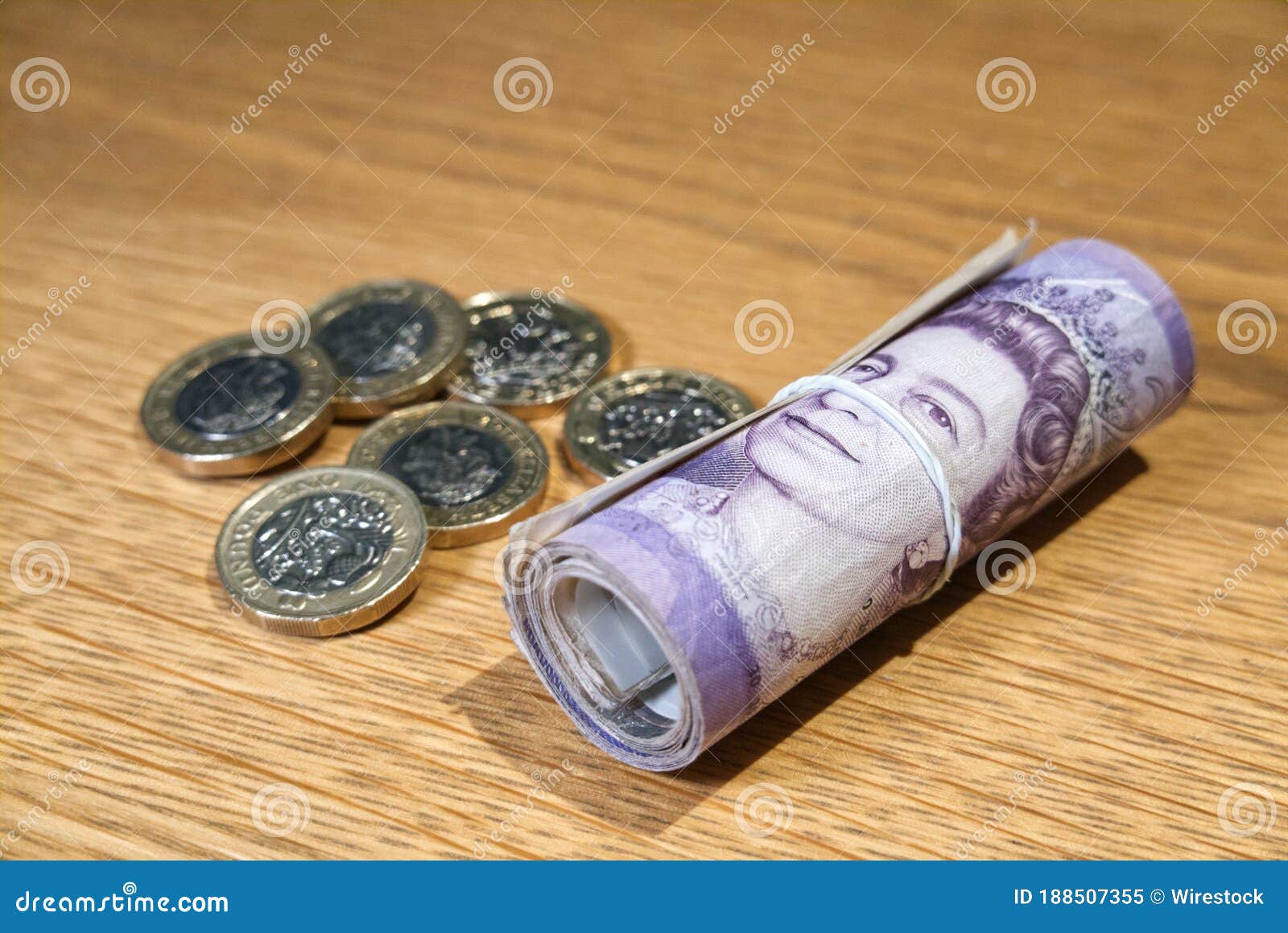 UK Pound Sterling Coins and a Roll of Banknotes on the Table Editorial ...