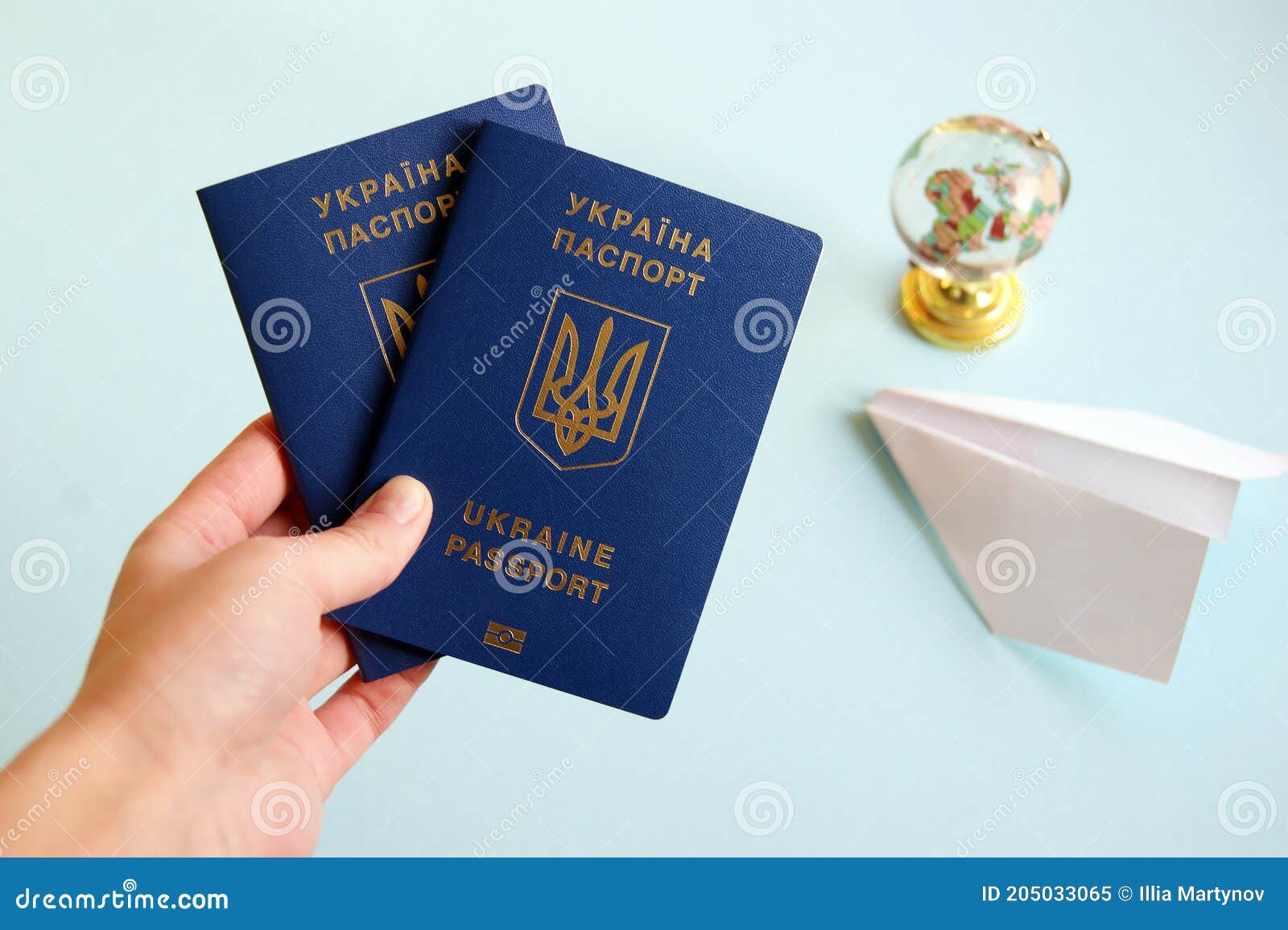 Ukrainian Biometric Passports In The Hands Of A Woman On A Light Blue