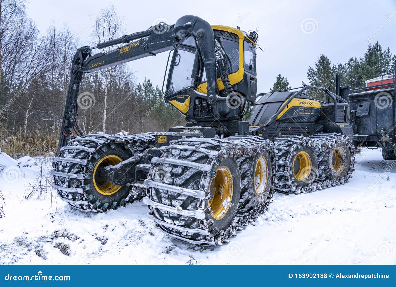A Forestry Machine Loads A Log Truck At The Site Landing. Forest ...