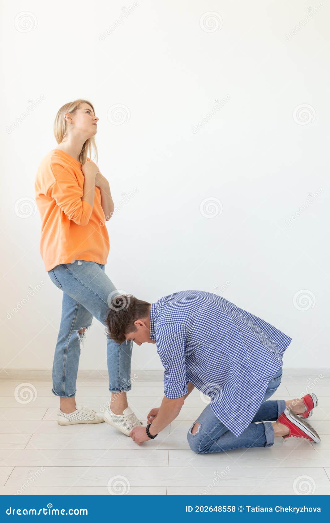 Un Hombre Joven Se Arrodilla Y Le Ata Cordones De Zapatos a Su ... Un Hombre Joven Se Arrodilla Y Le Ata Cordones De Zapatos a Su ...