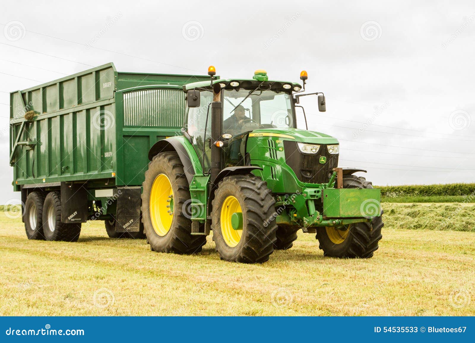 Un Tractor De John Deere Y Un Remolque Verdes De Bailey Foto de archivo ...