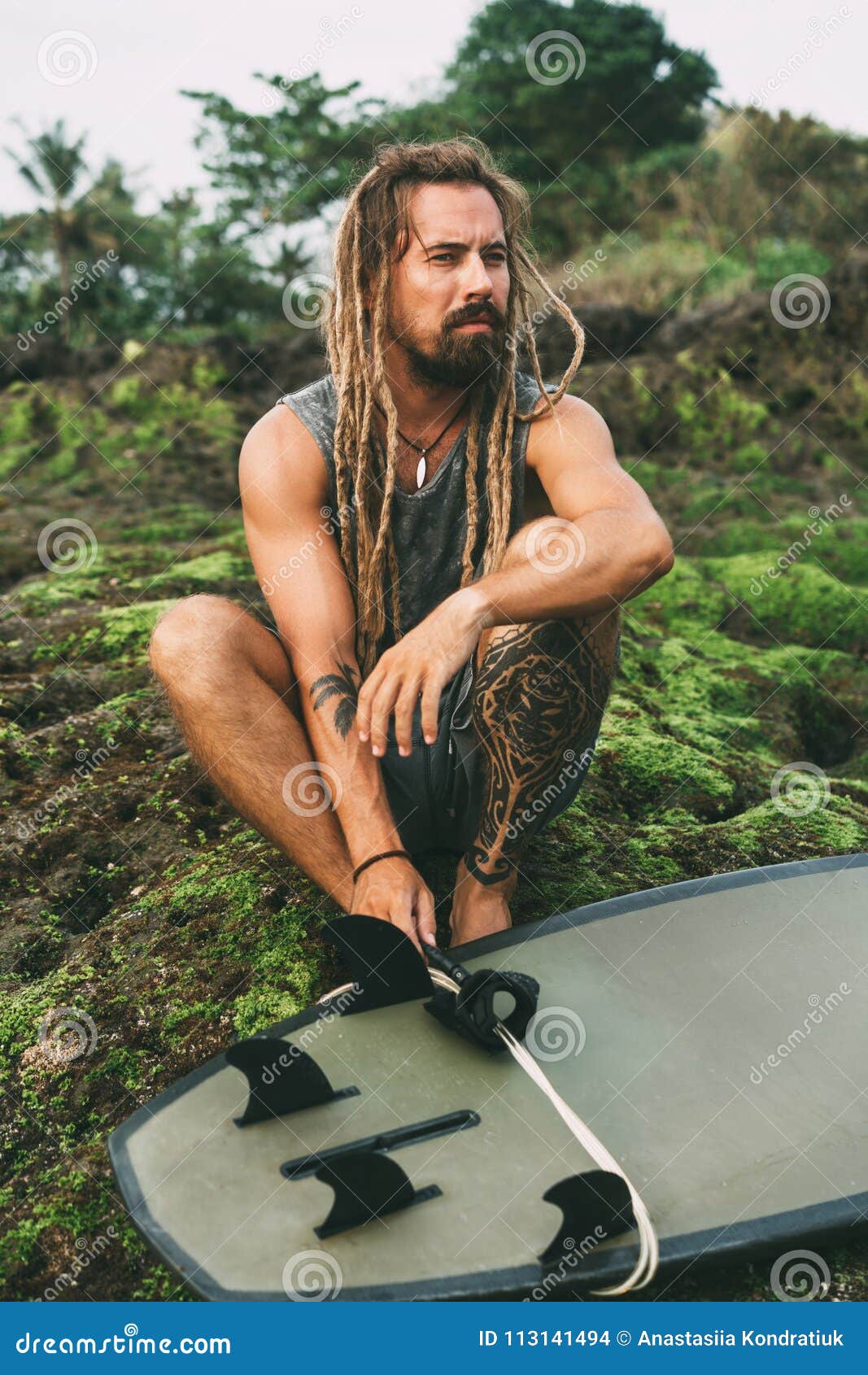Un Uomo Con I Dreadlocks, I Tatuaggi Ed Il Surf Fotografia Stock ...