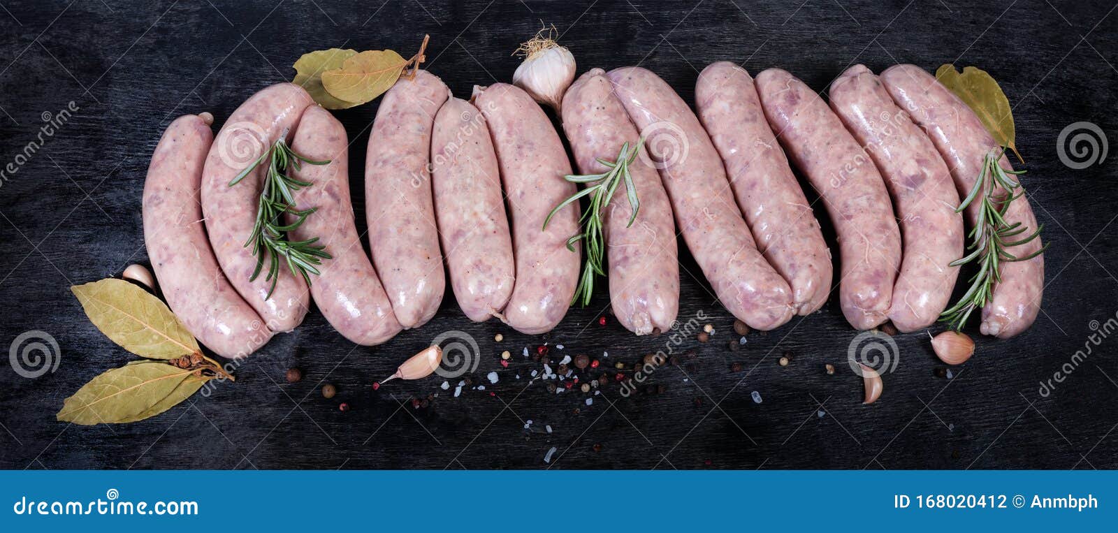 Uncooked Pork Sausages Among Spices On Dark Surface Top View Stock