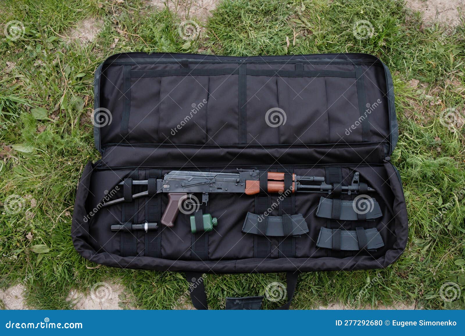 Uncovered Gun Case with AK-47, Magazines, and Flashlight Lying on the ...