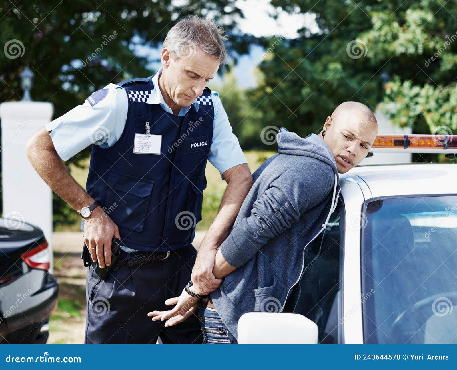 Under Arrest. Shot of a Policeman Arresting a Suspect. Stock Photo ...