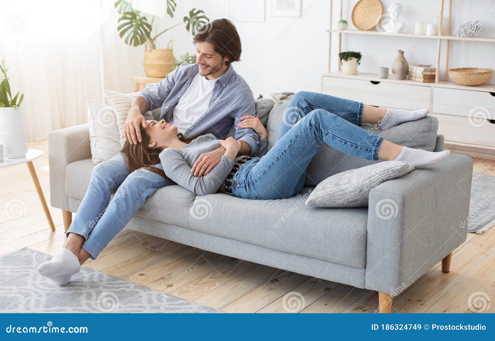 Underbart Ungt Par Som Klumpar På Soffan Hemma Fotografering För