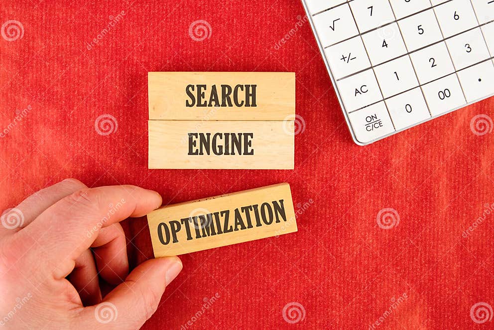 Understanding Search Engine Optimization with Wooden Blocks and Calculator on Red Background ...