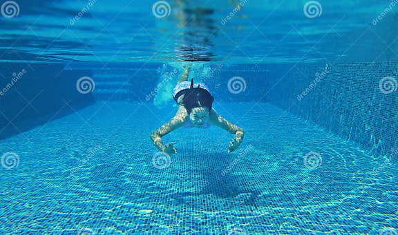 Underwater Shot Of Young Woman Diving Into The Swimming Pool Stock