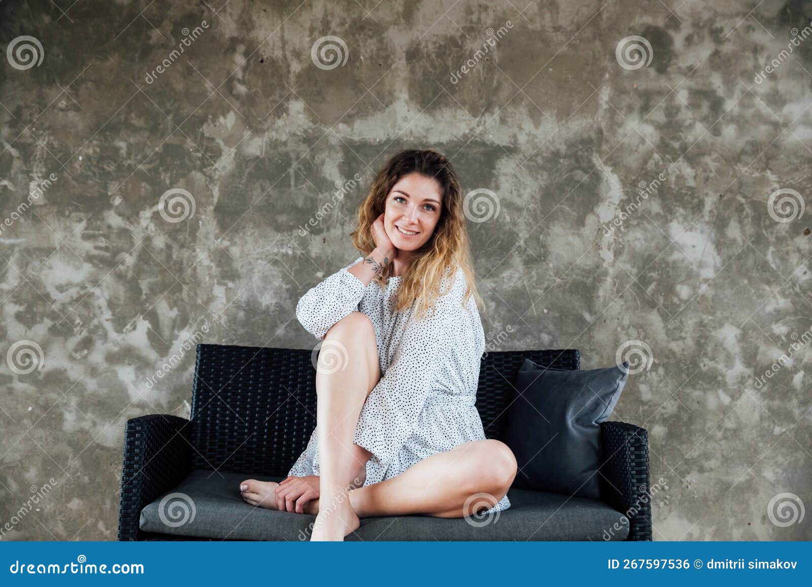 Une Belle Femme Assise Sur Une Chaise Dans Une Salle Grise Photo Stock