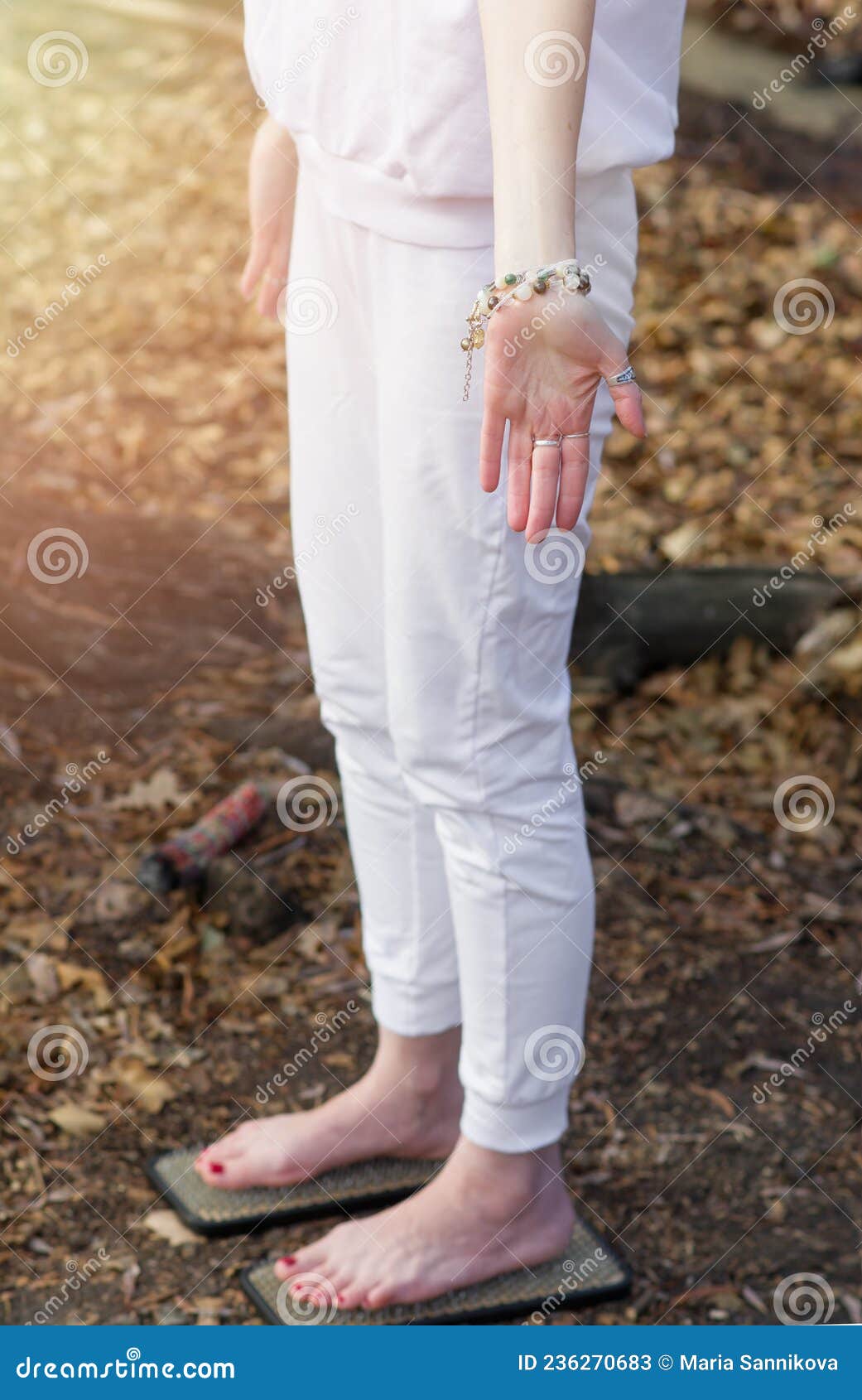 Une Femme En Vêtements Blancs Se Tient Pieds Nus Sur Un Tableau Avec