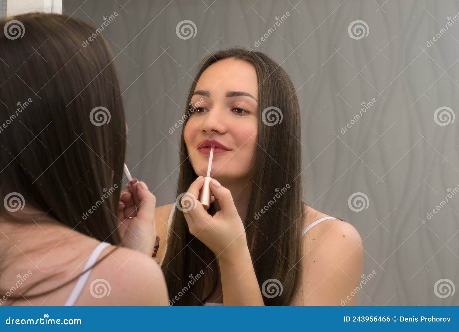 Une Jeune Fille Se Tient Devant Un Miroir Et Se Maquille Sur Le Visage