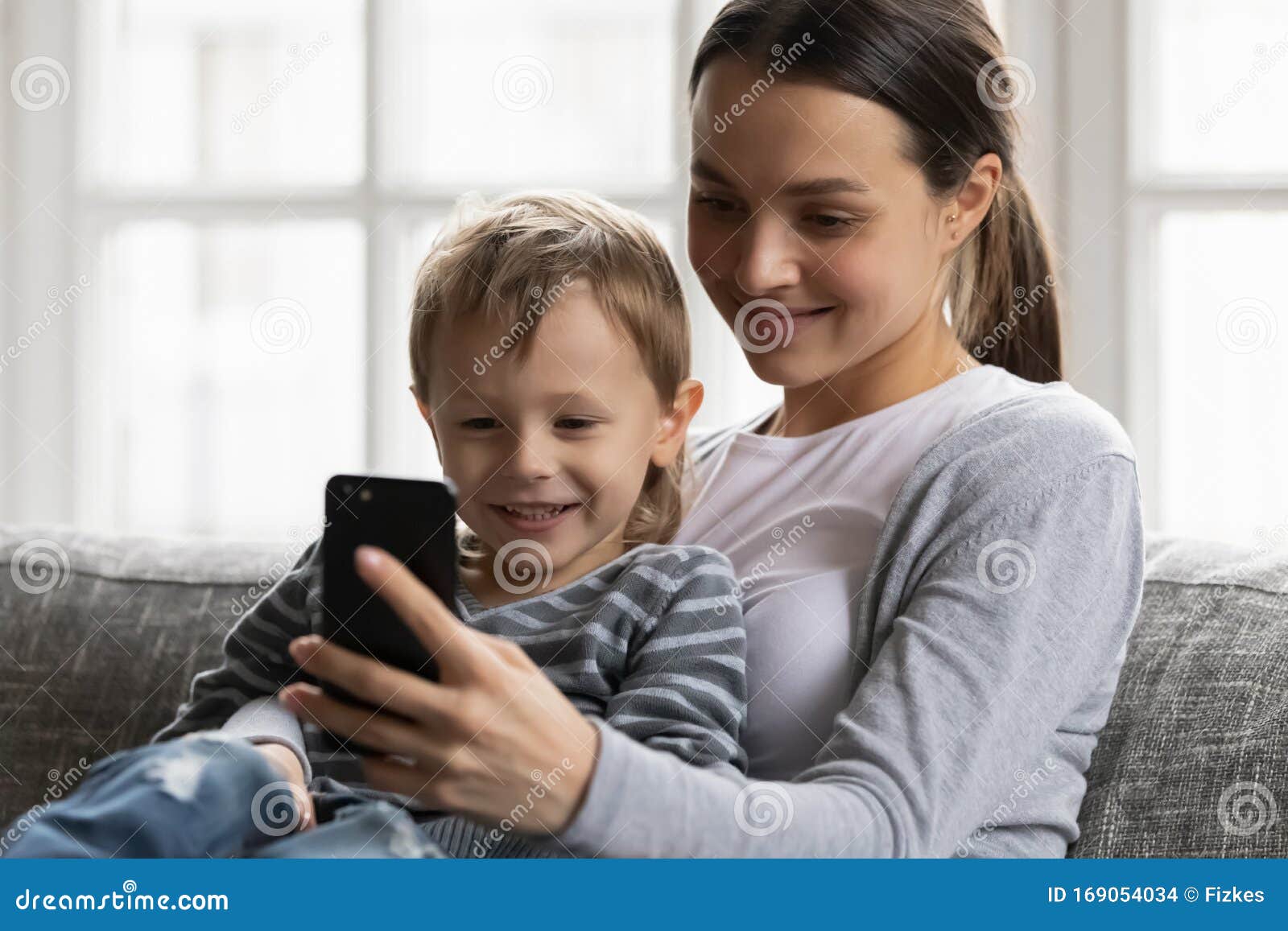 Ung Mamma Och Liten Son Tittar På Video I Cell Tillsammans Arkivfoto