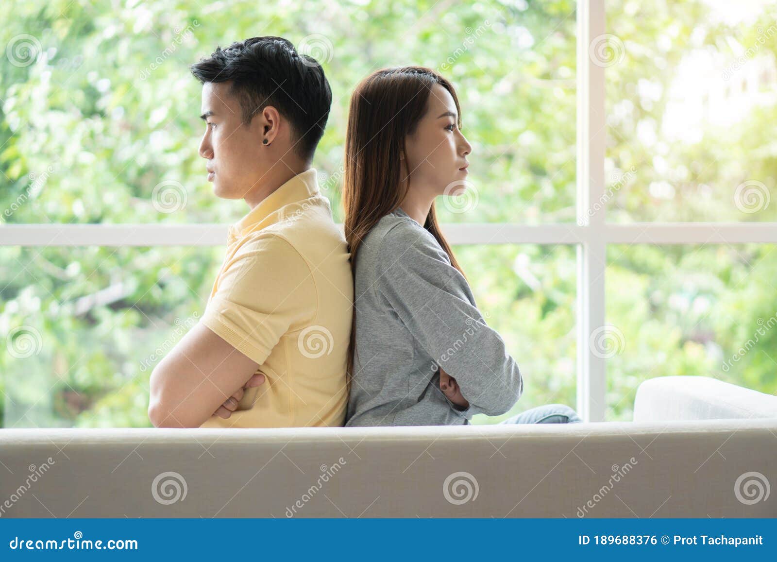 Unhappy Couple Sitting Behind Each Other On The Couch And Avoid Talking