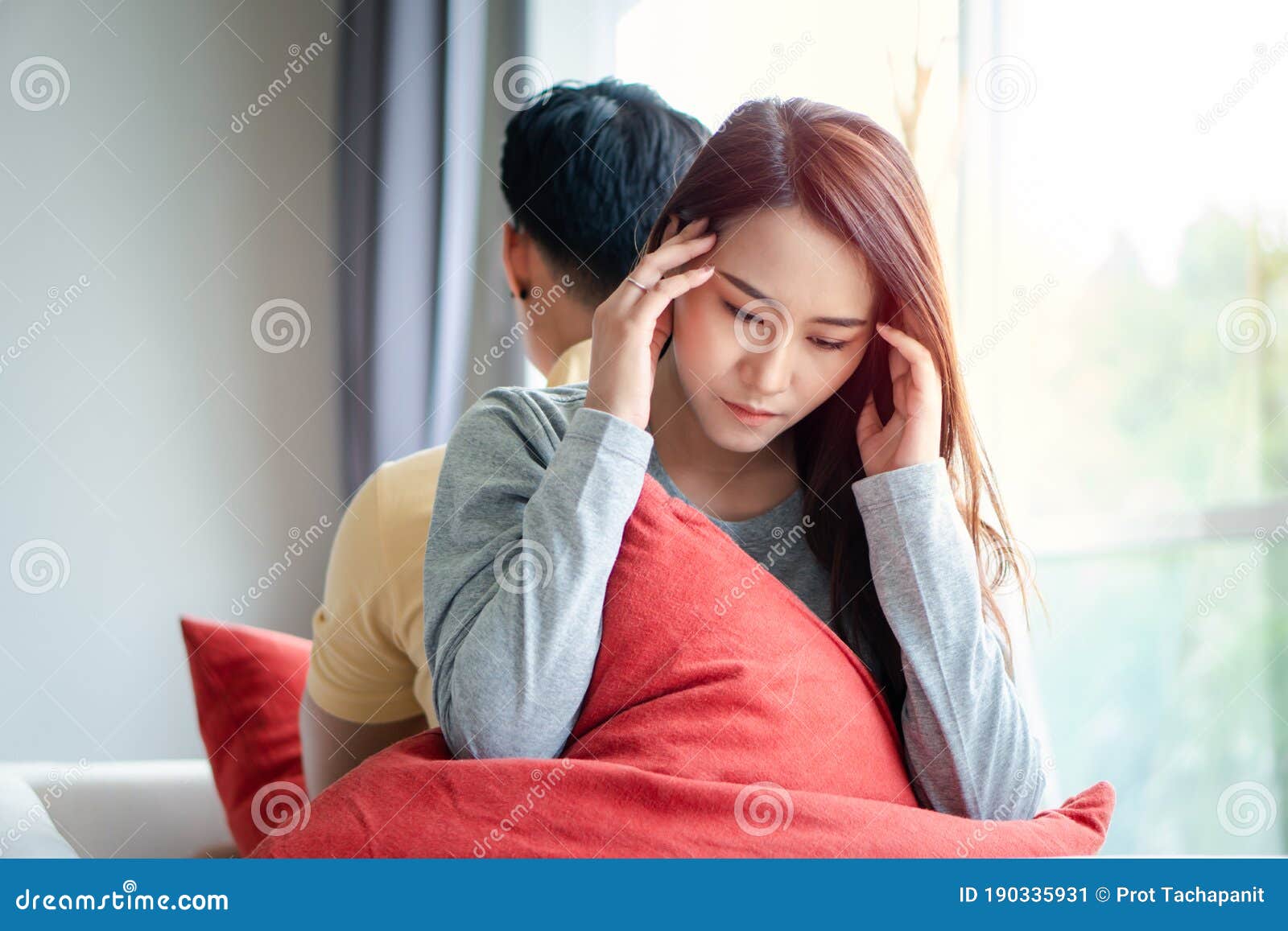 Unhappy Couple Sitting Behind Each Other On The Couch And Avoid Talking
