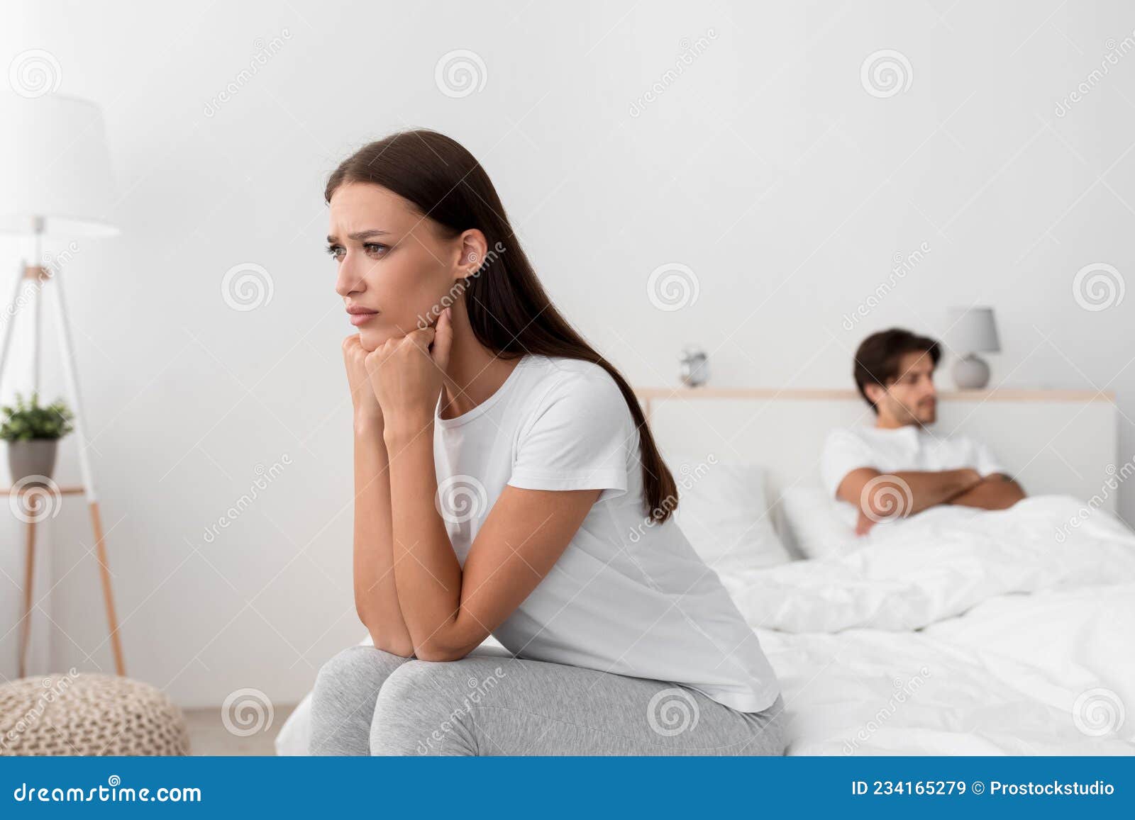 Unhappy Millennial Caucasian Lady Sits On Bed Ignores Offended Man In