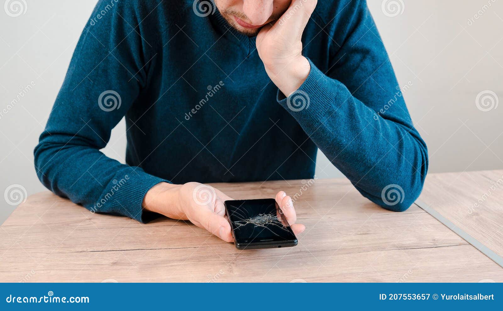 Unhappy Young Man Looking at His Smartphone with a Broken Screen. Stock ...