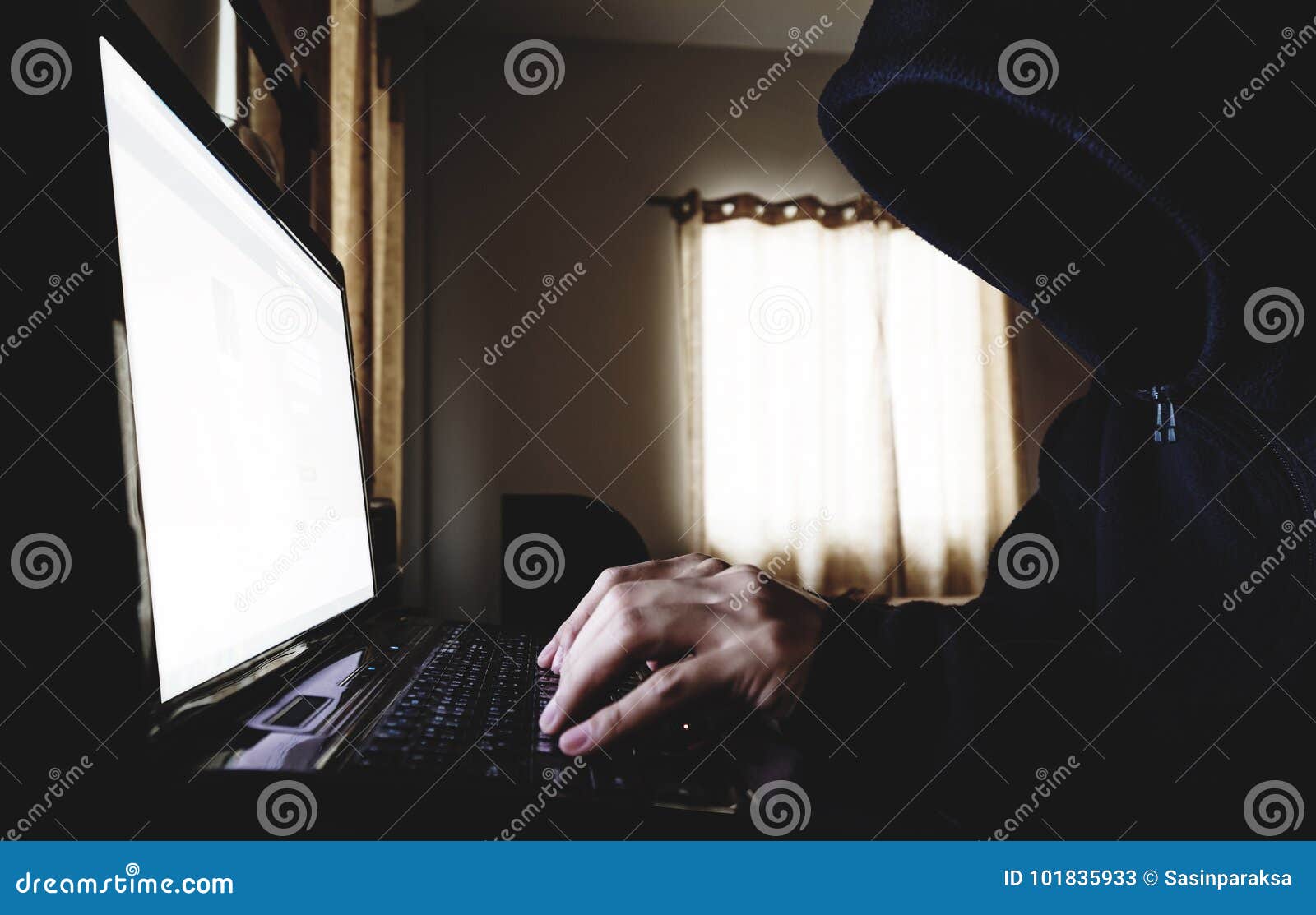 Unidentified Hacker in Black Hood Using Laptop Computer in Dark Room ...