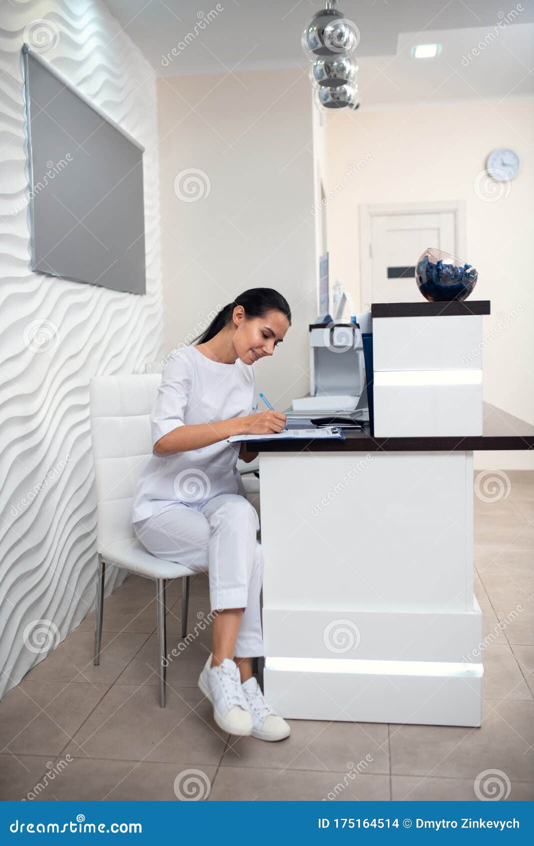 Receptionist Wearing White Uniform and Sneakers Making Notes Stock ...