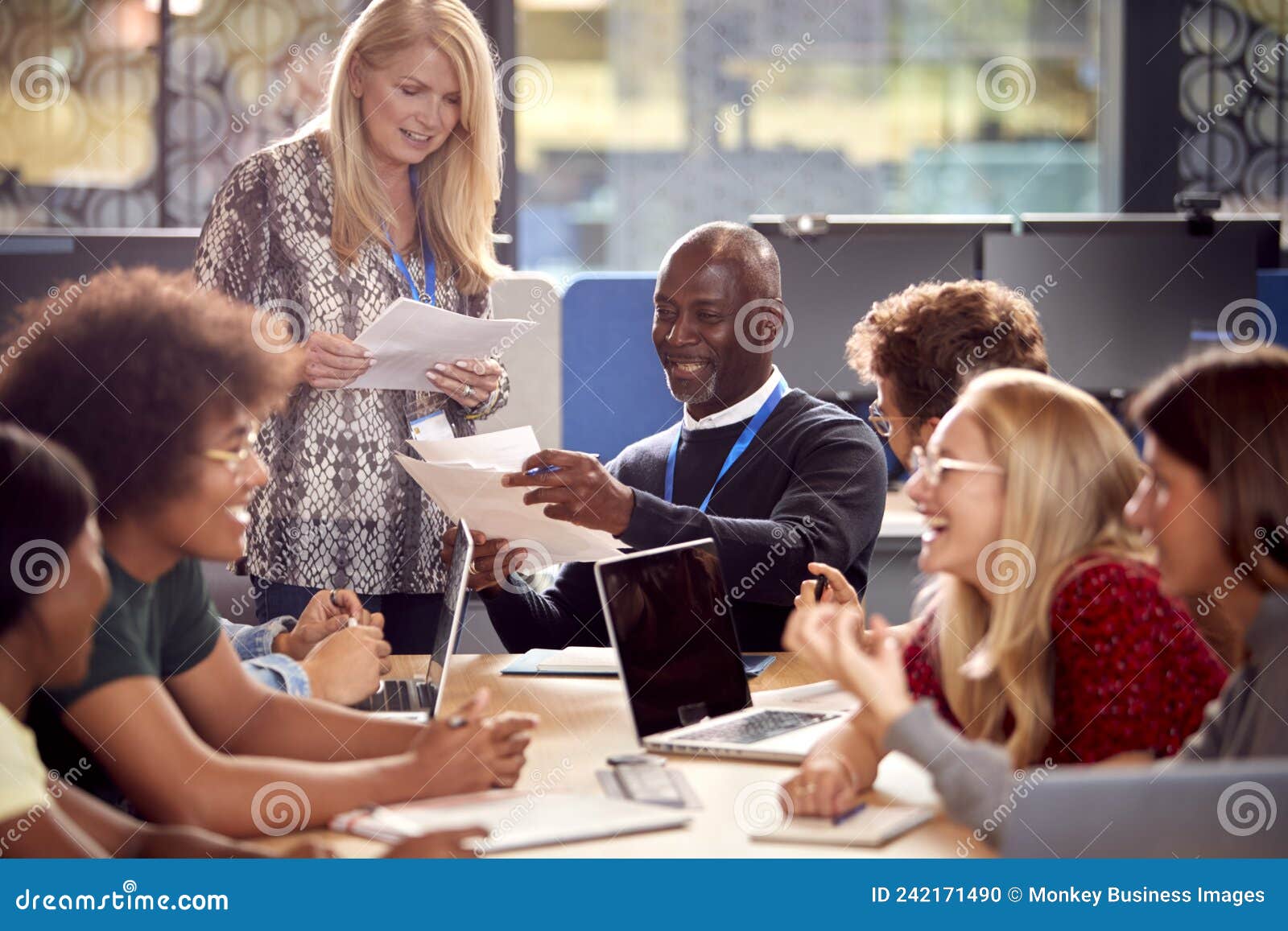 University or College Students Sitting Around Table with Tutor ...