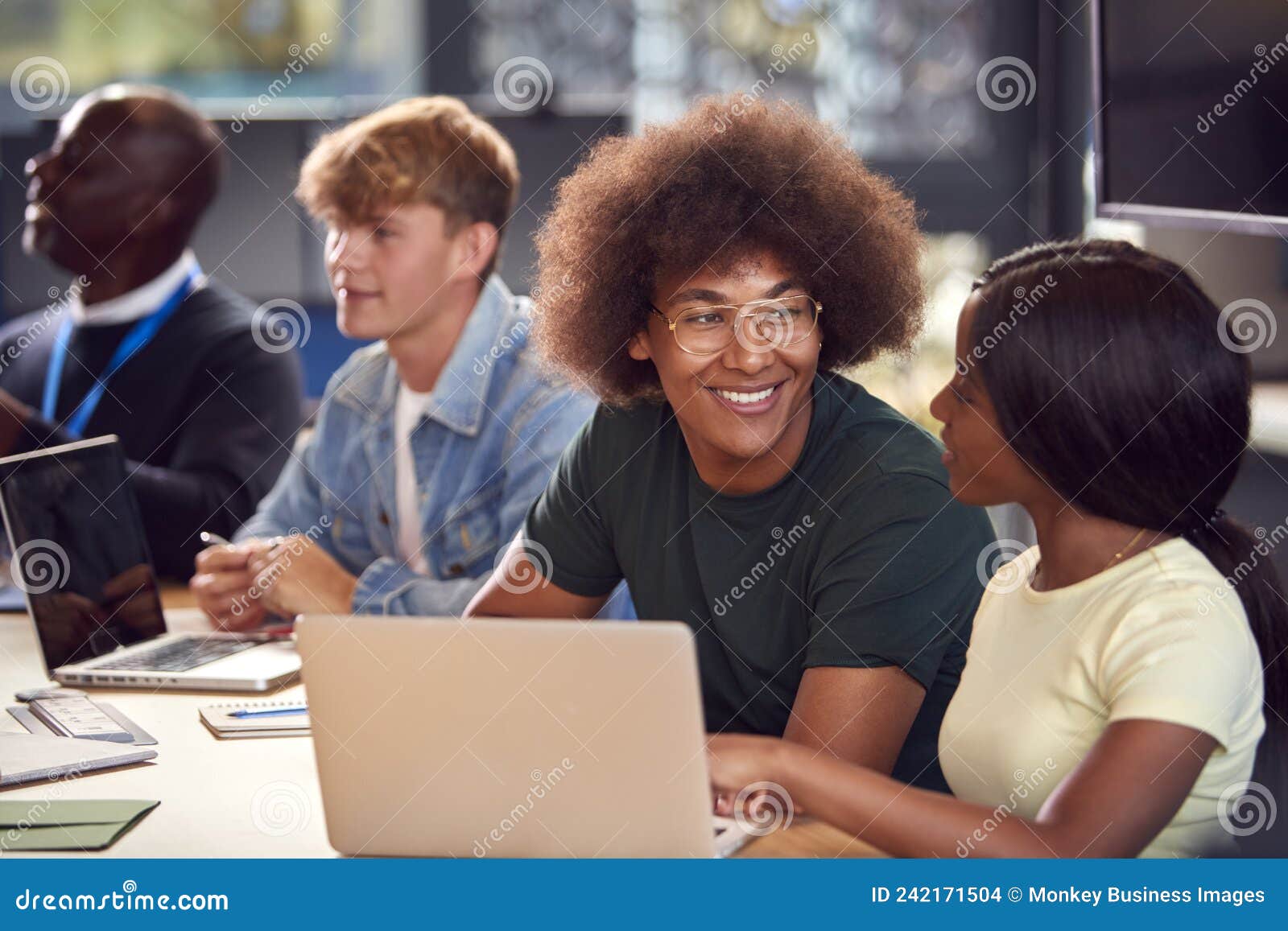 University or College Students Sitting Around Table with Tutor ...
