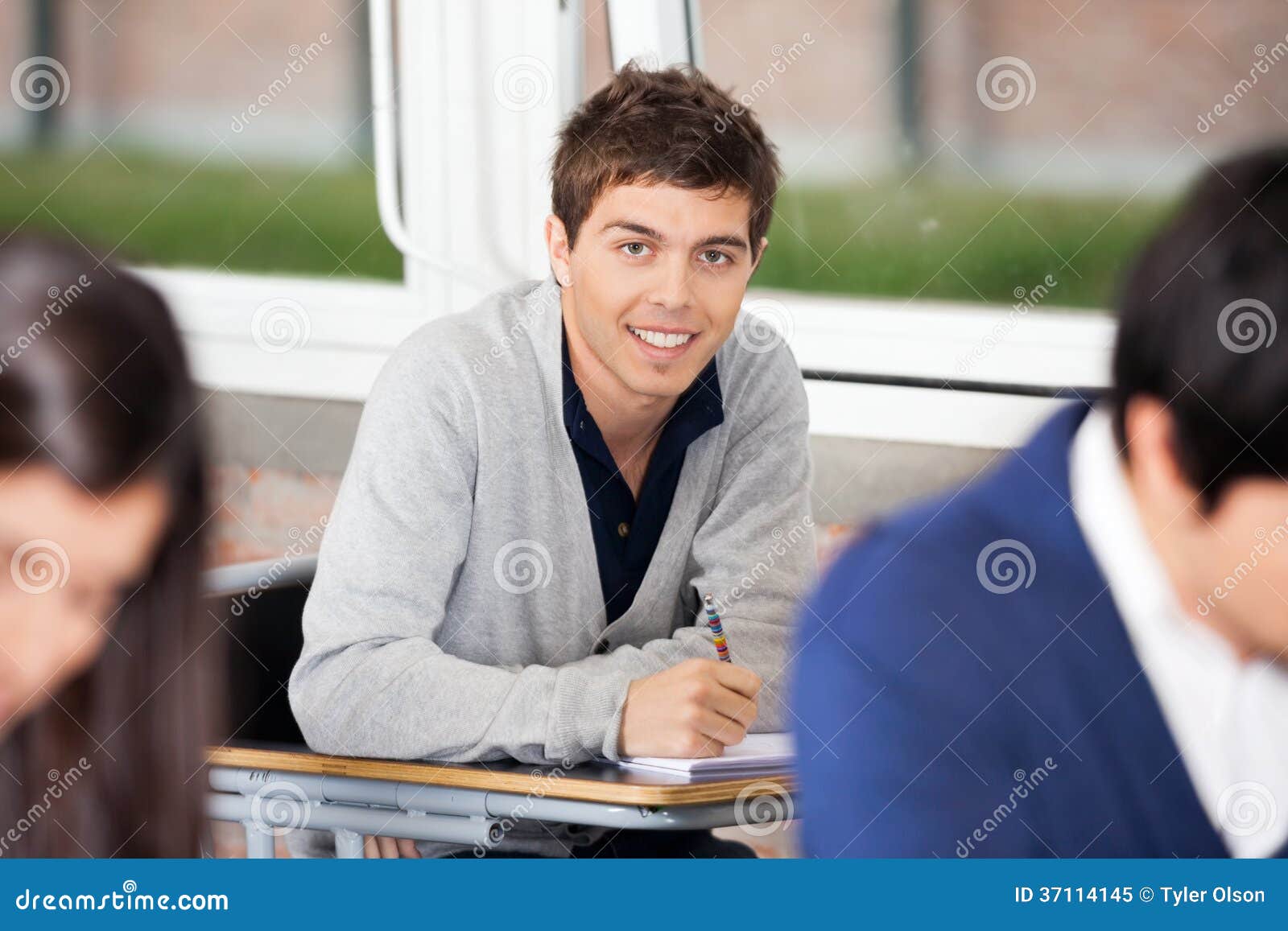 University Student Sitting at Desk with Classmates Stock Image - Image ...