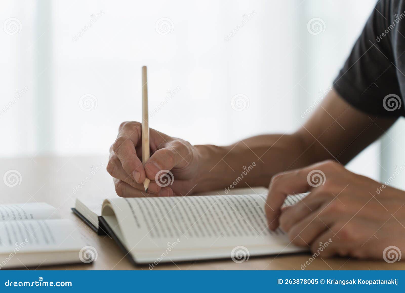 University Student Studying, Writing and Reading Book or Textbook ...