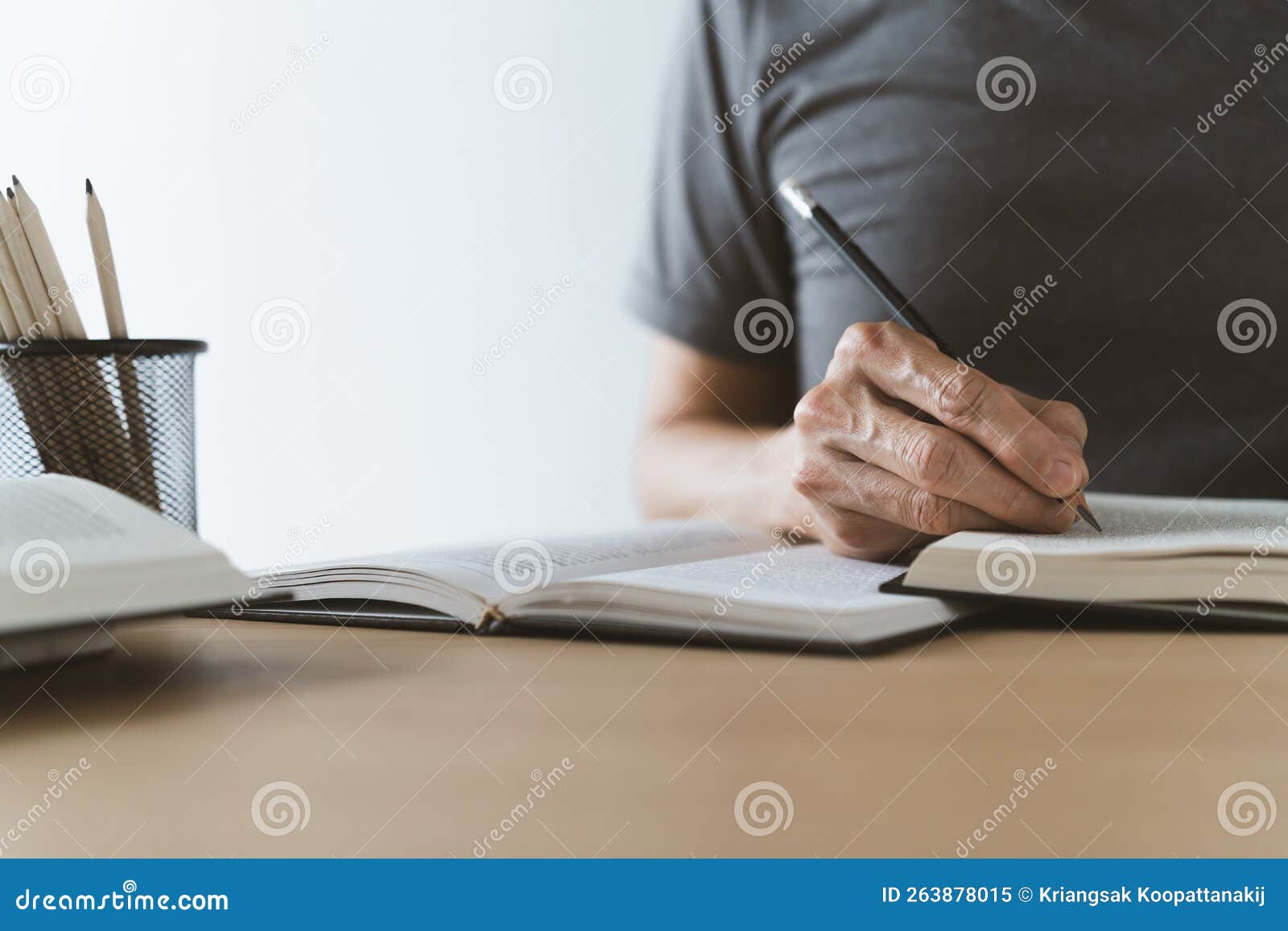 University Student Studying, Writing and Reading Book or Textbook ...