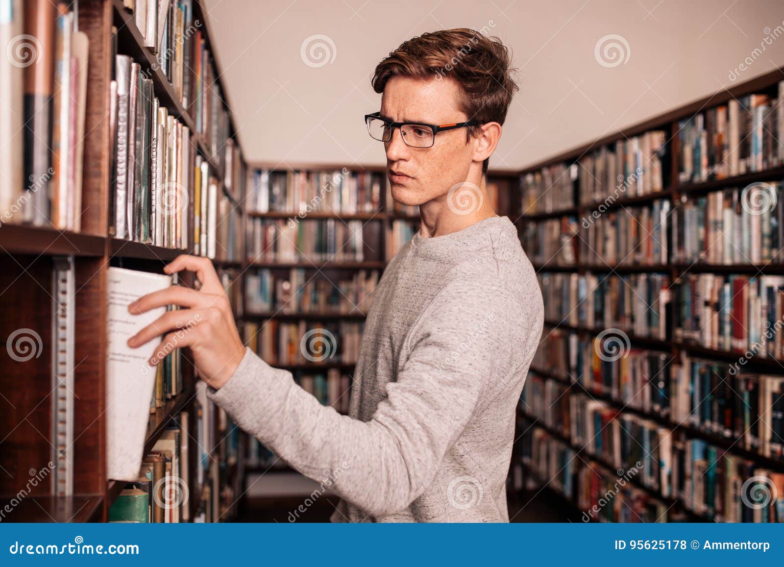 University Student Taking a Book from Shelf in Library Stock Photo ...