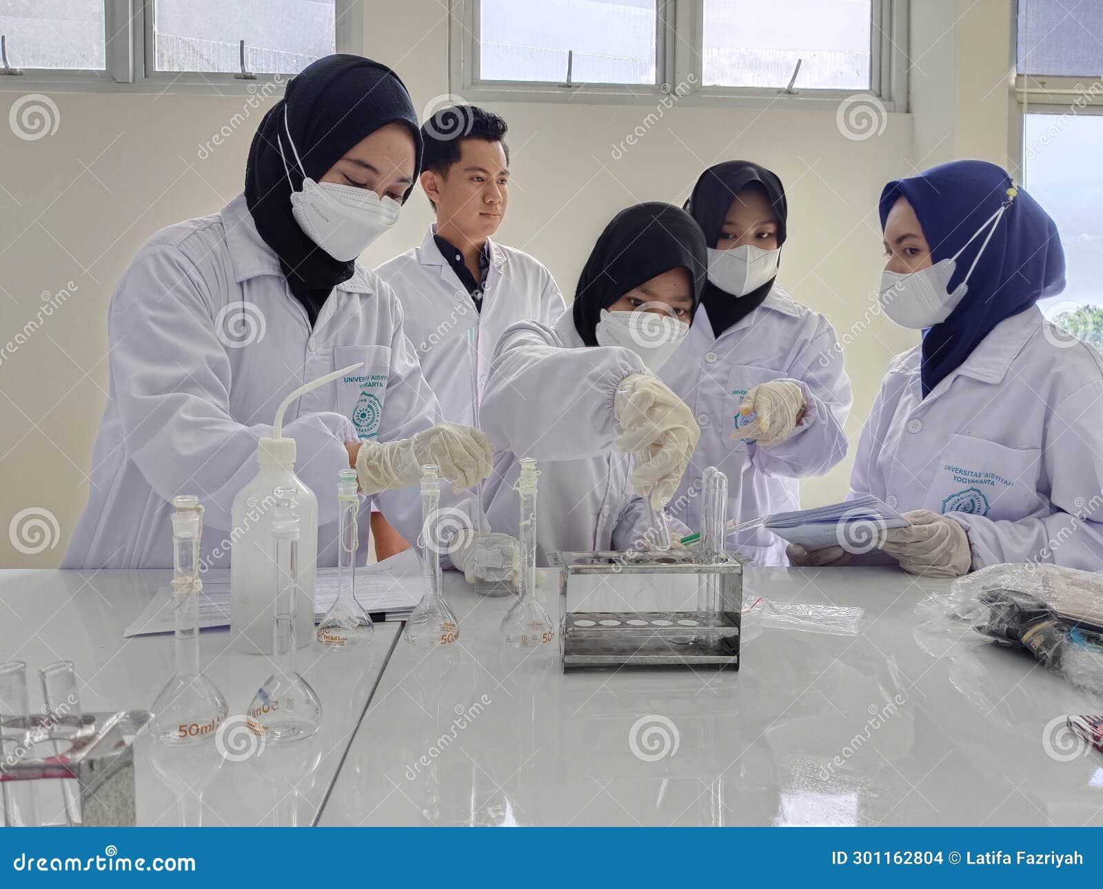 University Students Doing a Chemical Experiment in the Laboratory Using ...