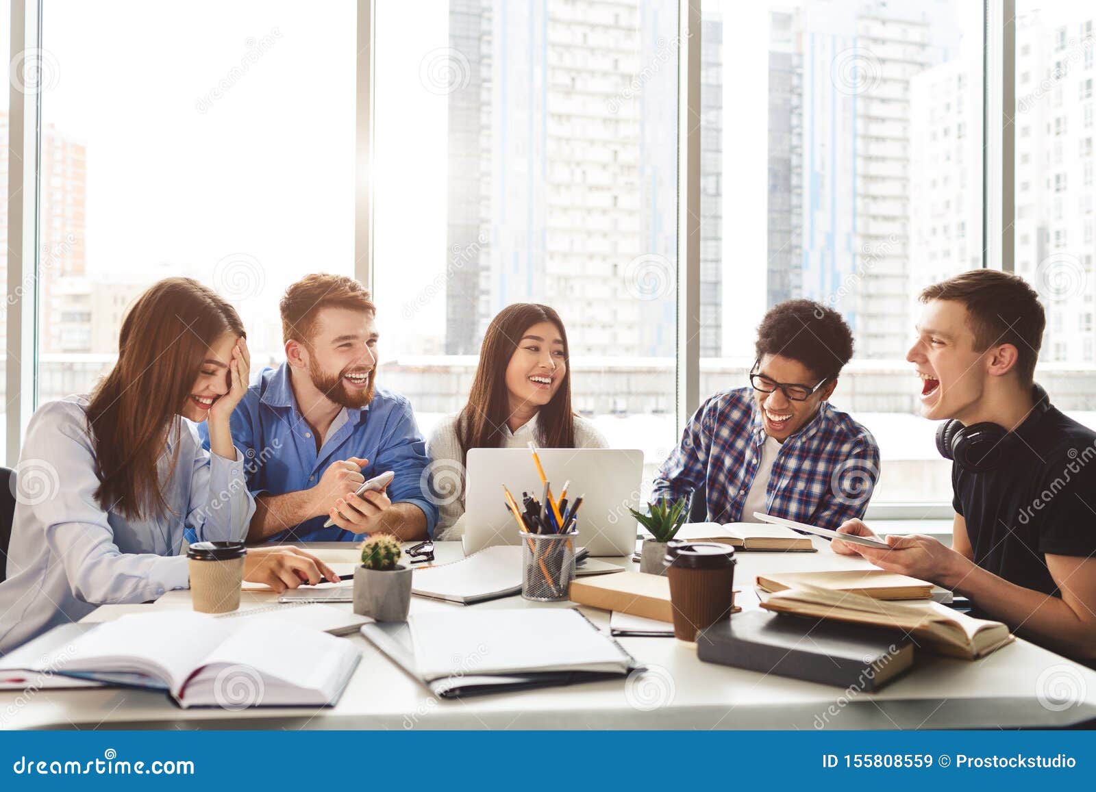 University Students Sitting Together at Table with Books and Laptop ...