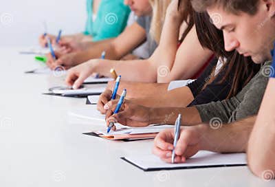 University Students Writing at Desk Stock Photo - Image of hispanic ...
