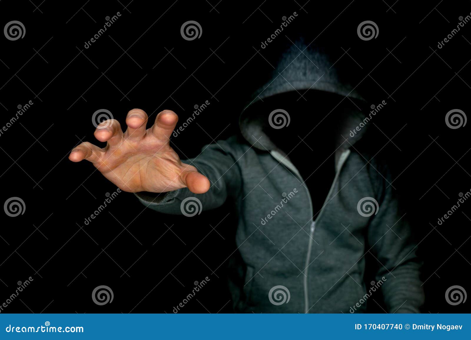 An Unknown Man in a Hood Reaches with His Hand with His Terrible Hand ...