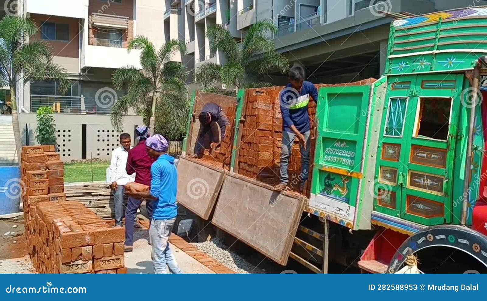 Unloading Bricks Form the Truck on a Construction Site. Workers are ...